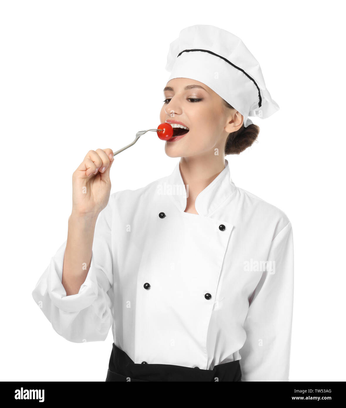 Young female chef eating tomato on white background Stock Photo - Alamy