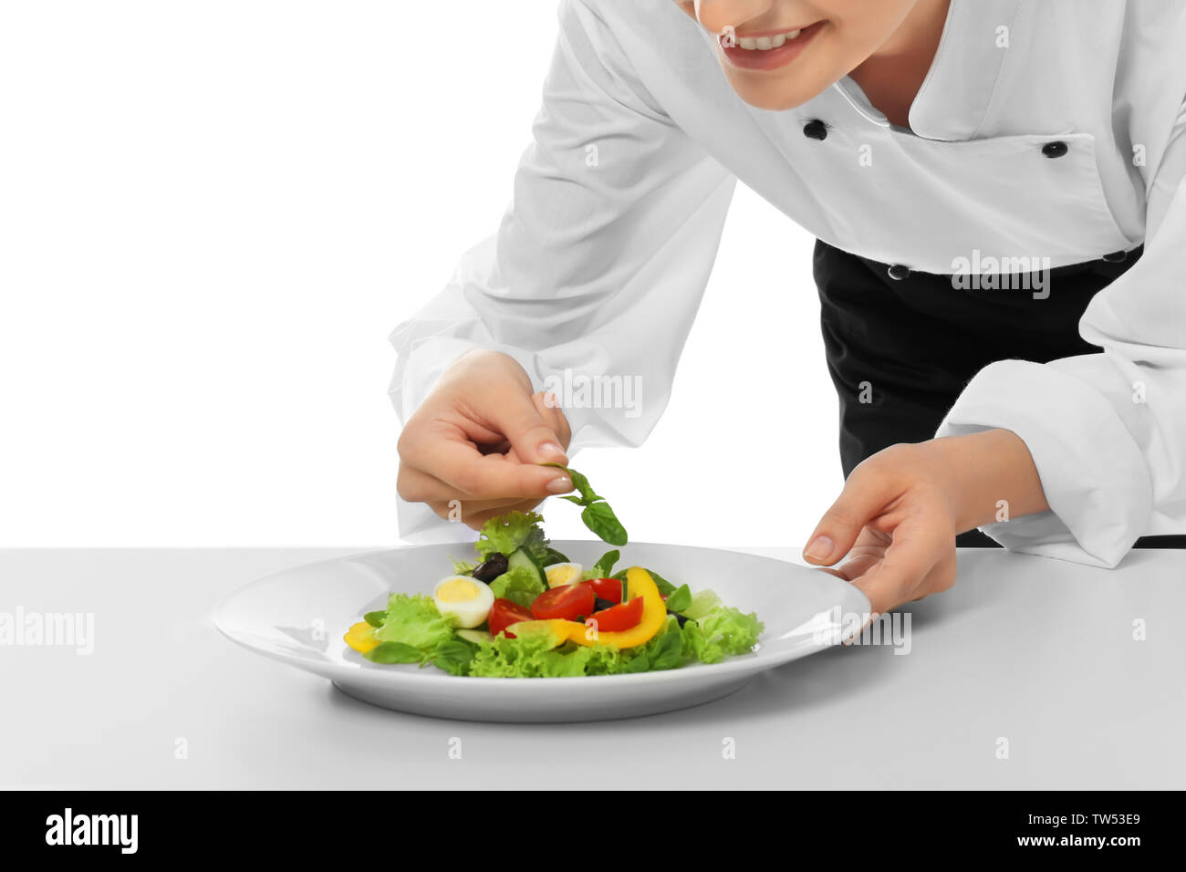 Young female chef making salad on white background Stock Photo - Alamy
