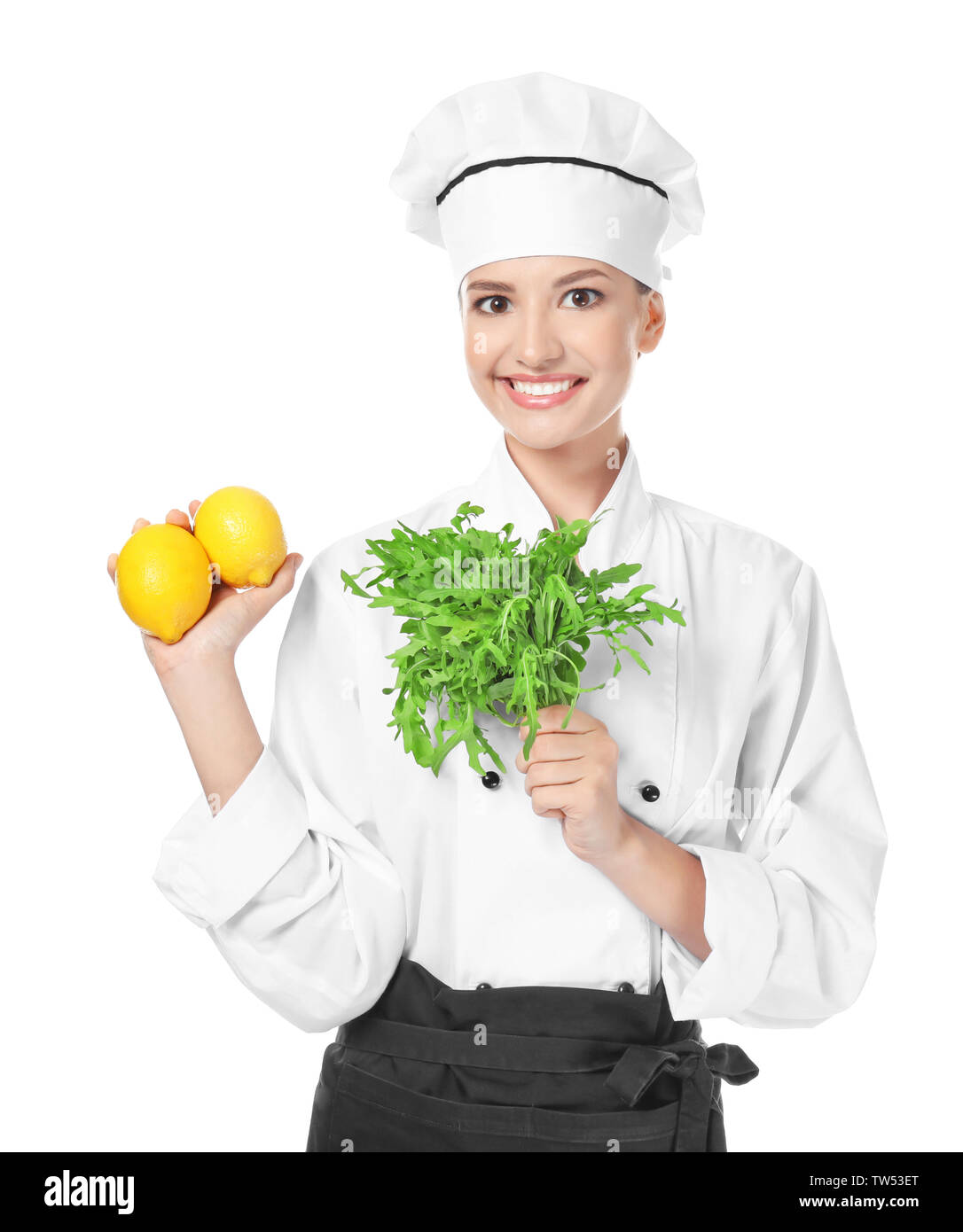 Young female chef with ruccola and lemons on white background Stock ...