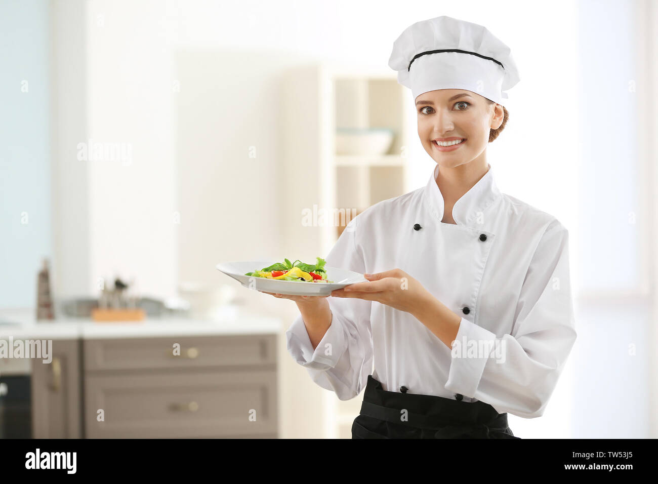 Young female chef with tasty dish in kitchen Stock Photo - Alamy