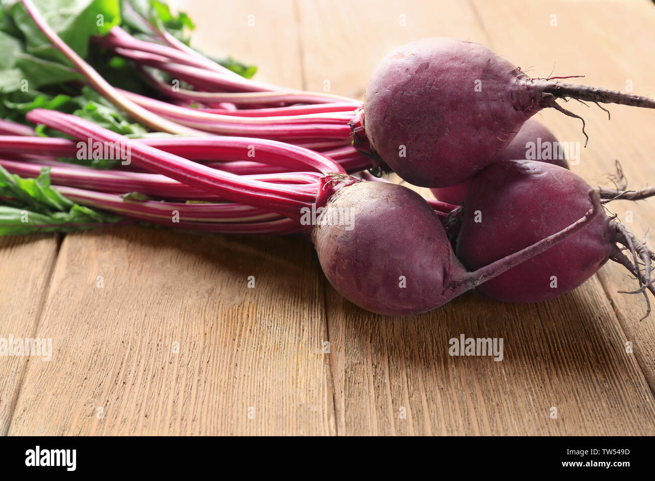 Bunch of young beets on wooden table Stock Photo - Alamy