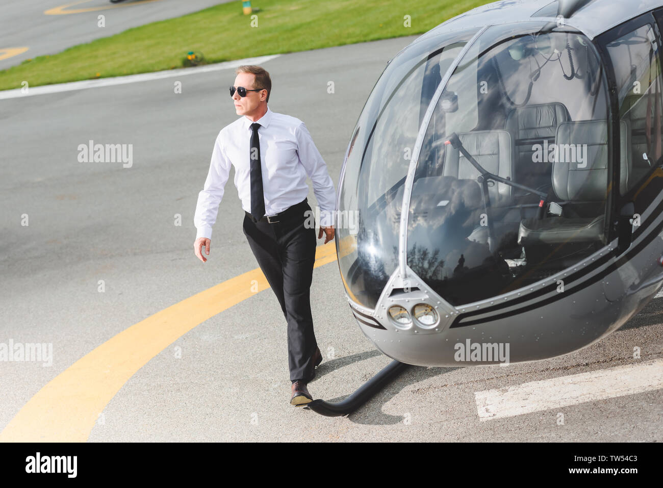 good-looking Pilot in formal wear and sunglasses walking near ...