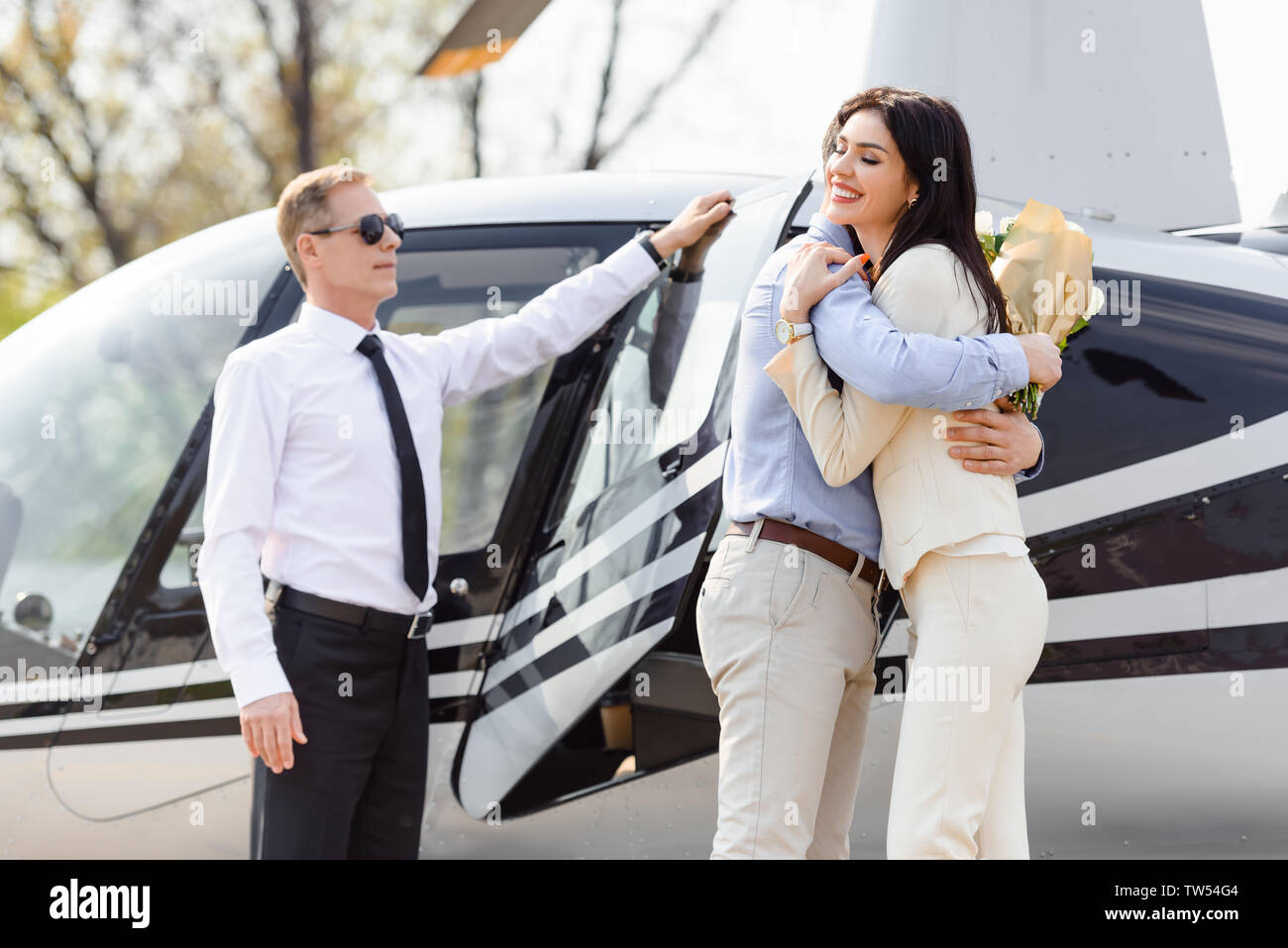 husband hugging wife on romantic date near helicopter and pilot Stock ...