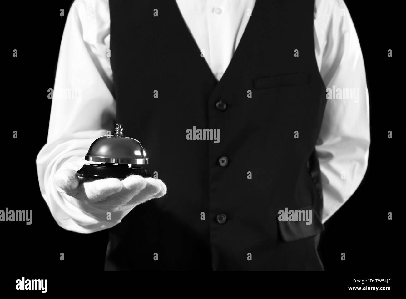 Man holding bell on black background, closeup Stock Photo - Alamy
