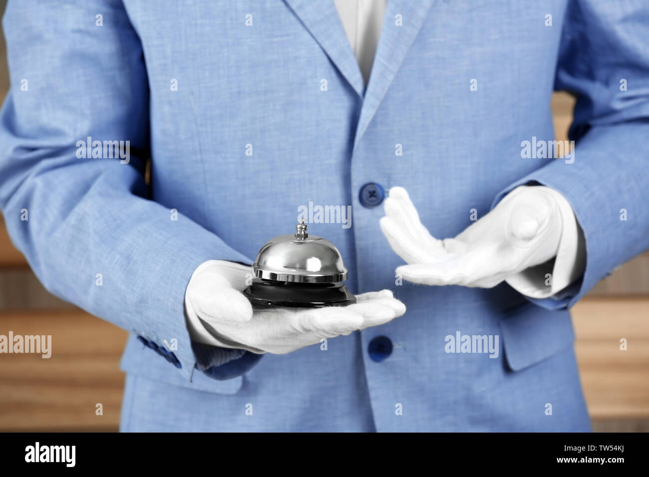 Man holding bell on blurred background, closeup Stock Photo - Alamy