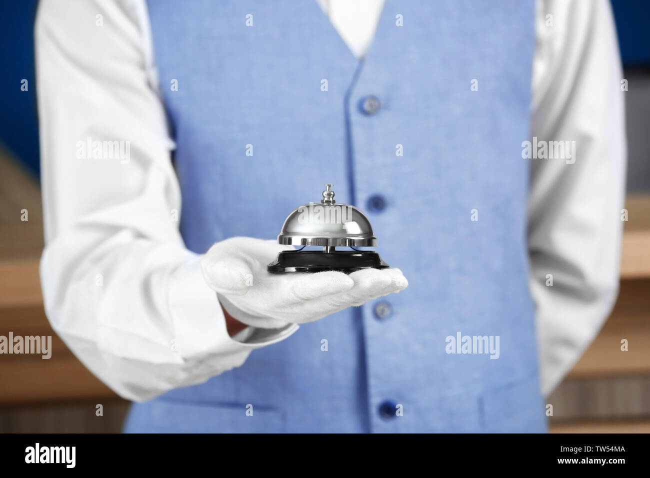 Man holding bell on blurred background, closeup Stock Photo - Alamy