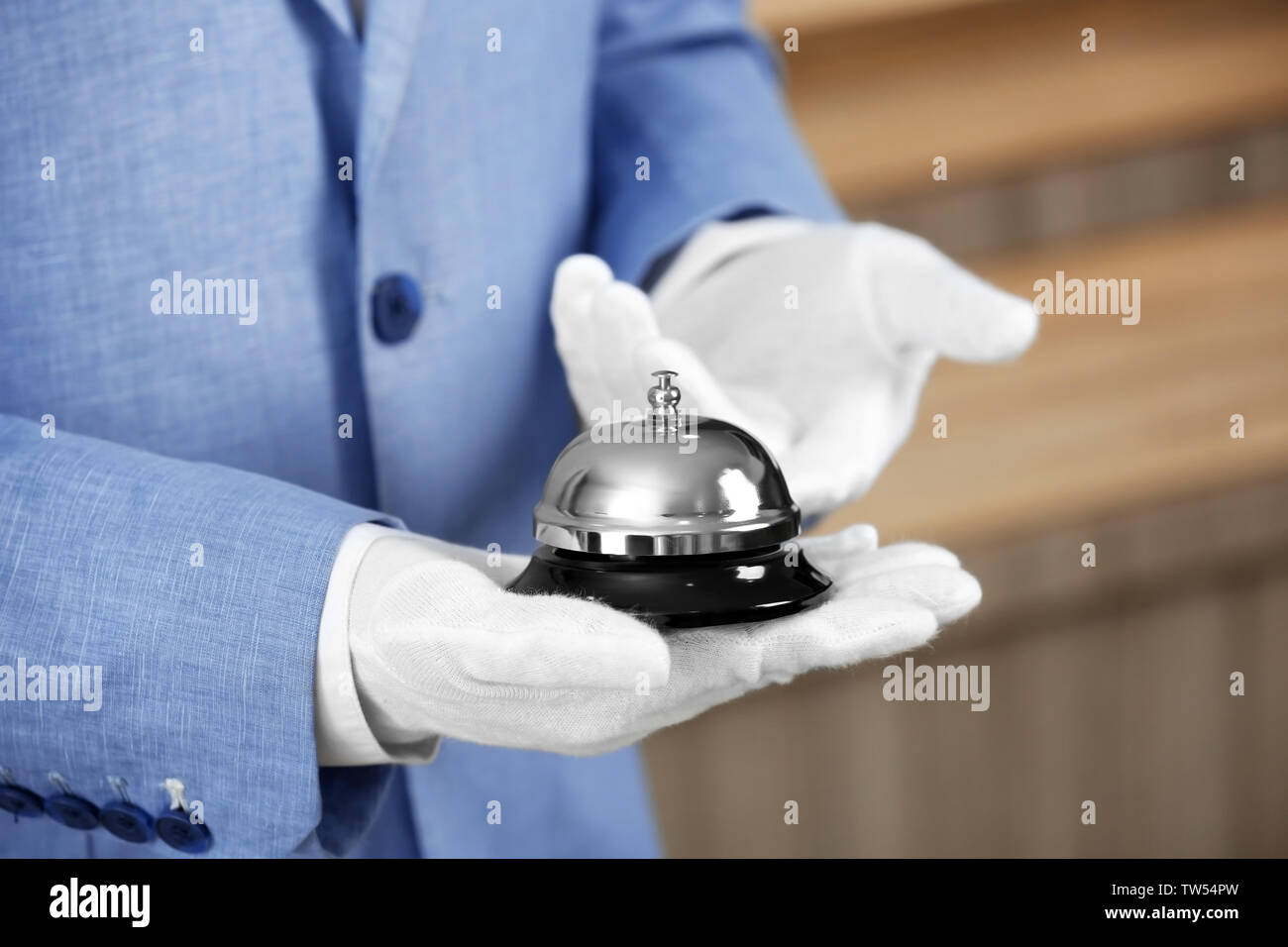Man holding bell on blurred background Stock Photo - Alamy