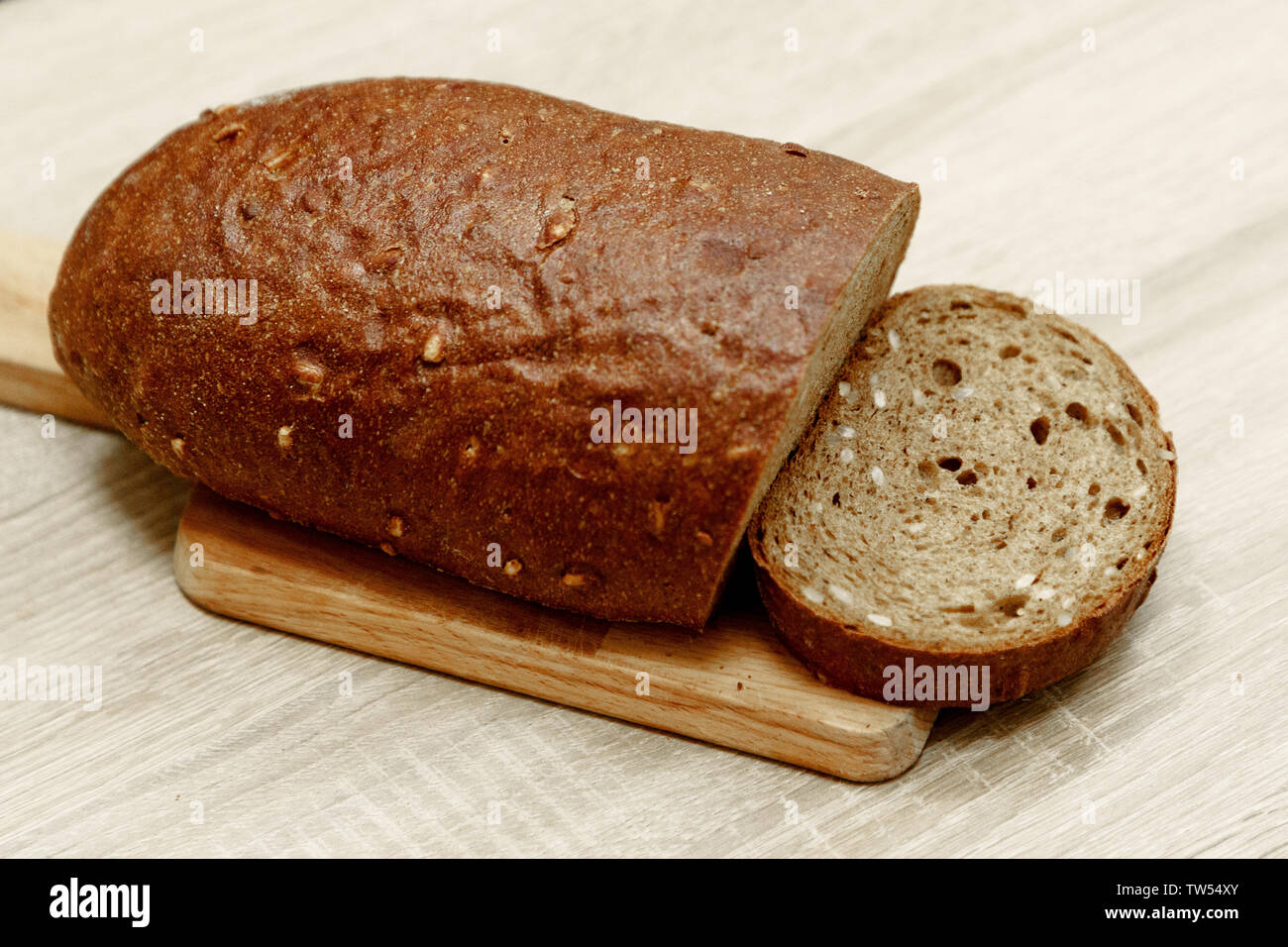 black baked bread and one sliced piece Stock Photo - Alamy