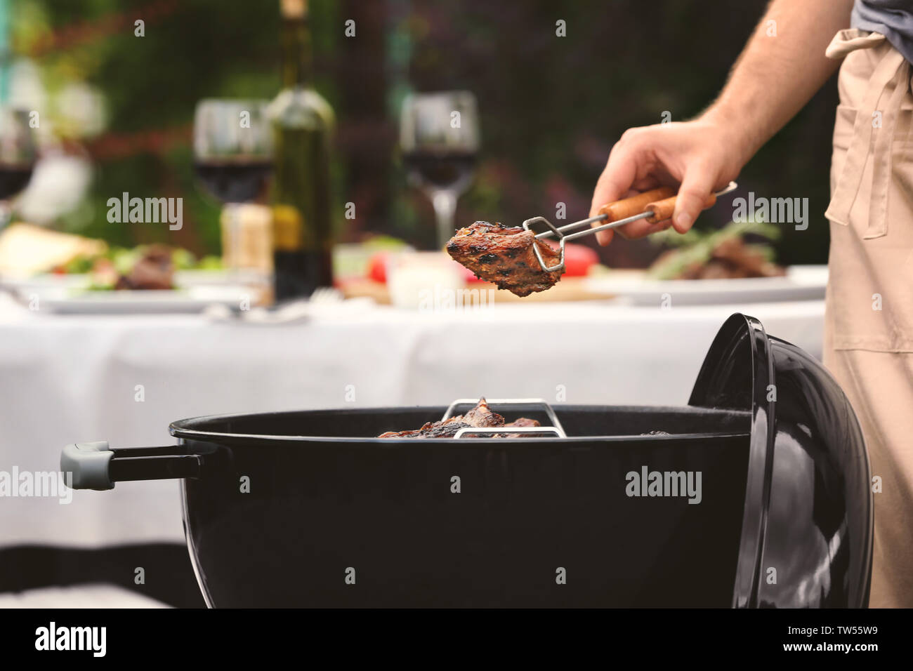 Man cooking ribs on barbecue grill Stock Photo - Alamy