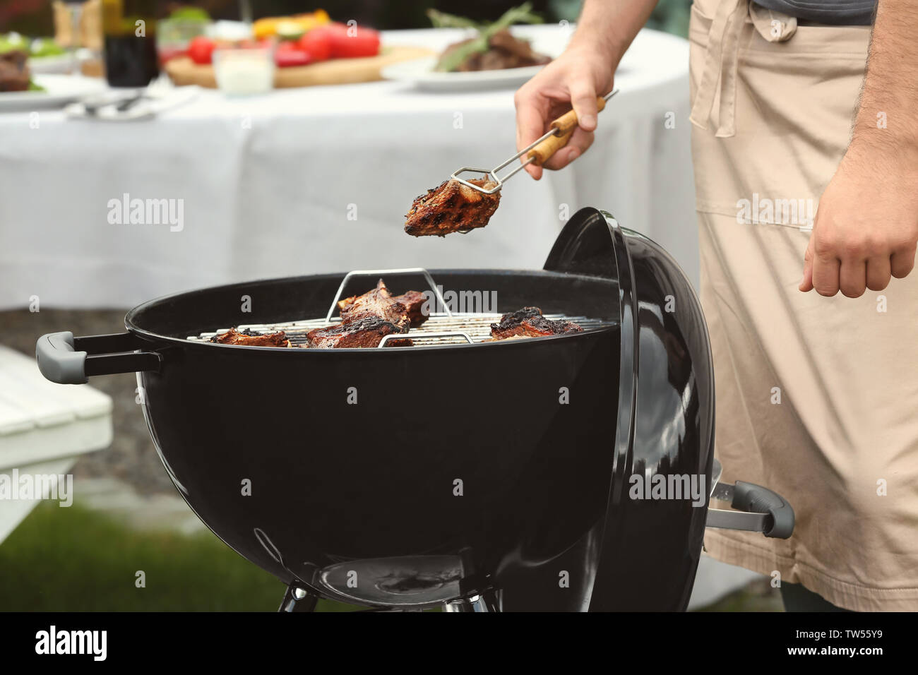 Man cooking ribs on barbecue grill Stock Photo - Alamy