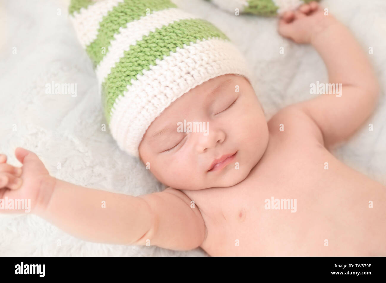 Cute little baby in knitted cap sleeping on bed at home Stock Photo - Alamy