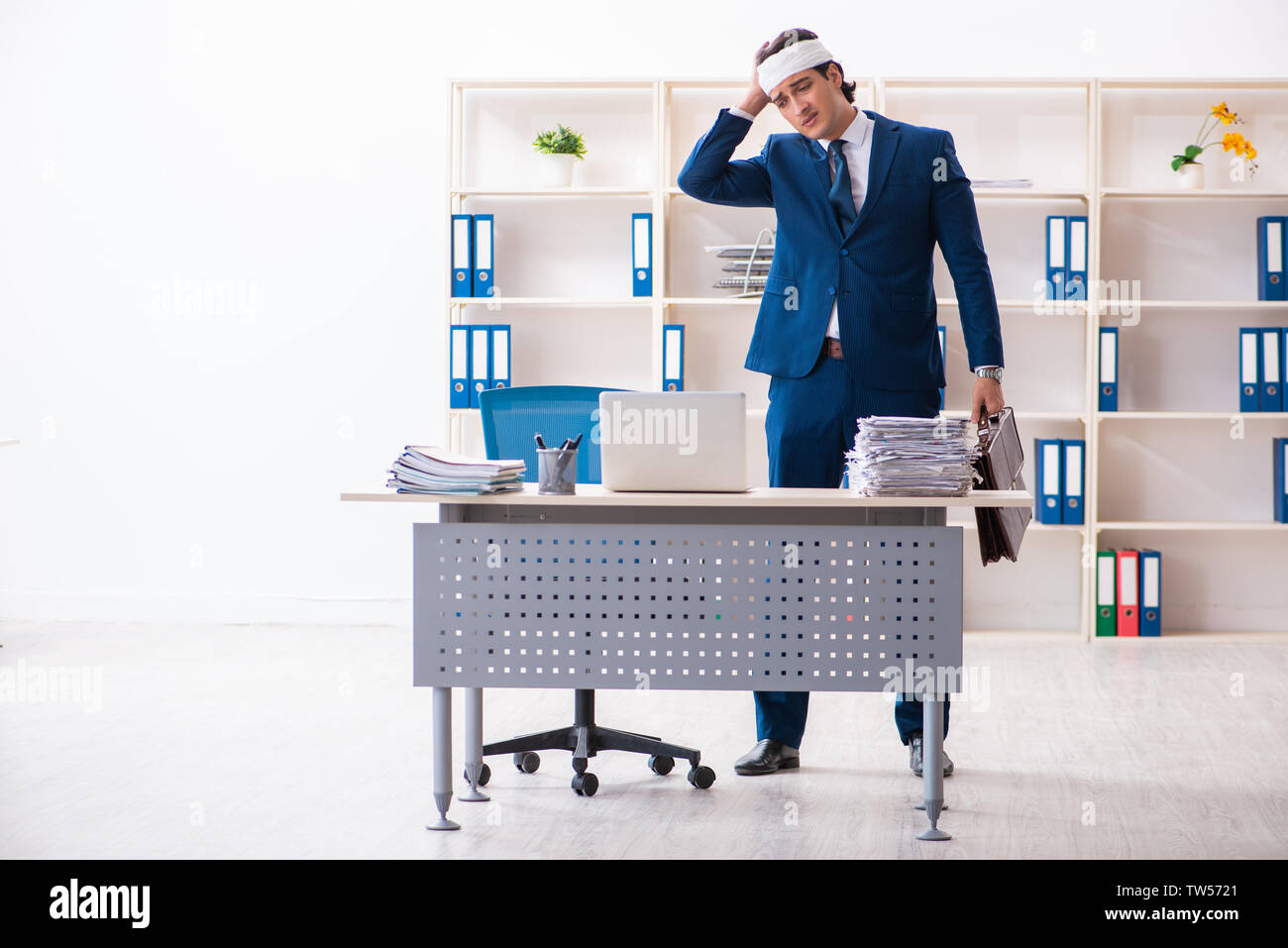 Head injured male employee working in the office Stock Photo - Alamy