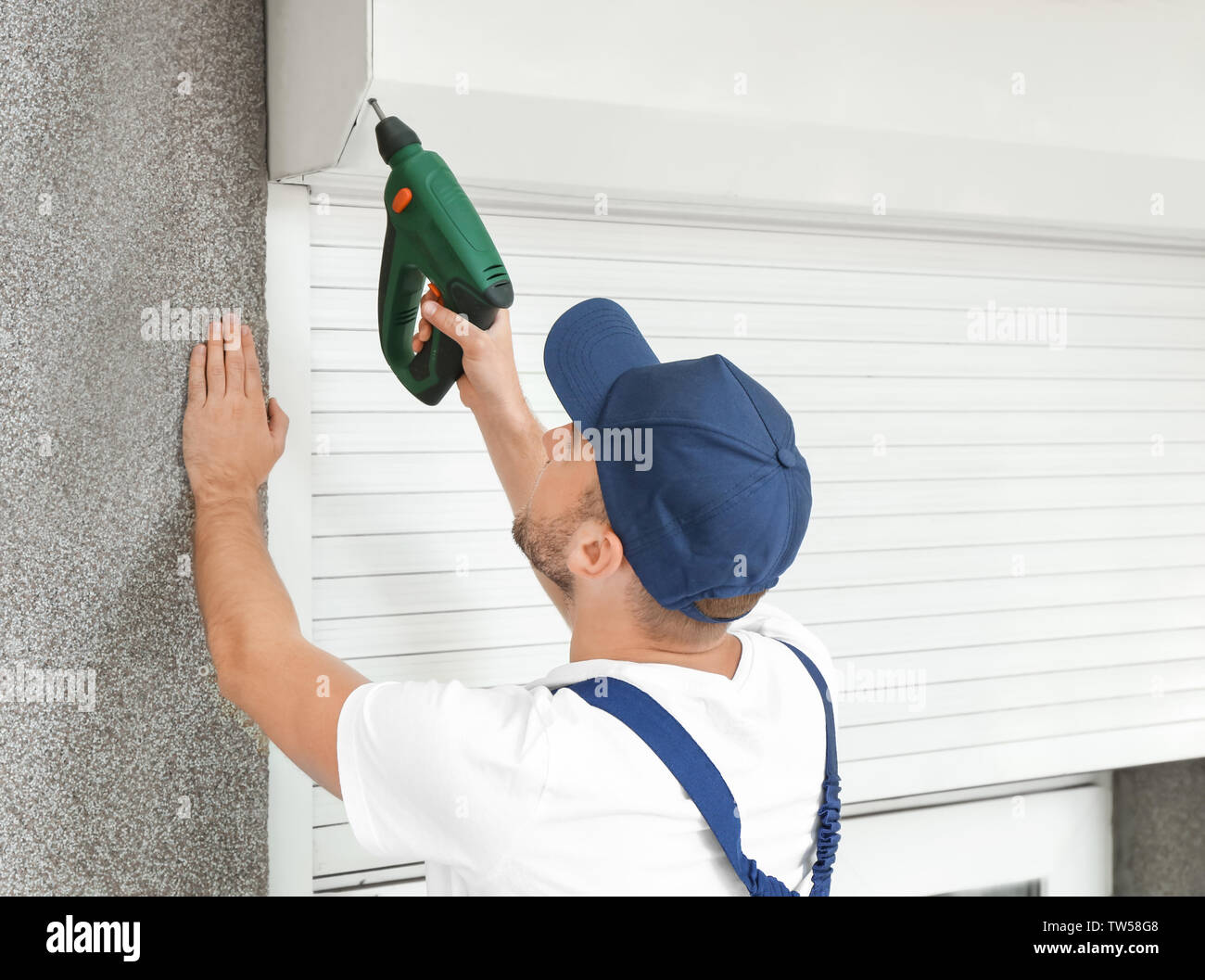 Man installing roller shutter on window Stock Photo - Alamy