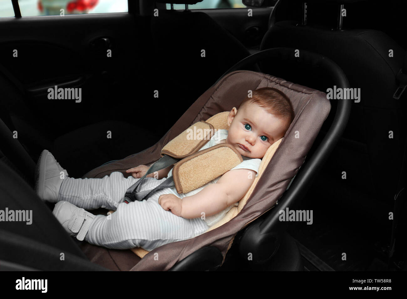 Adorable baby resting in child safety seat inside of car Stock Photo ...