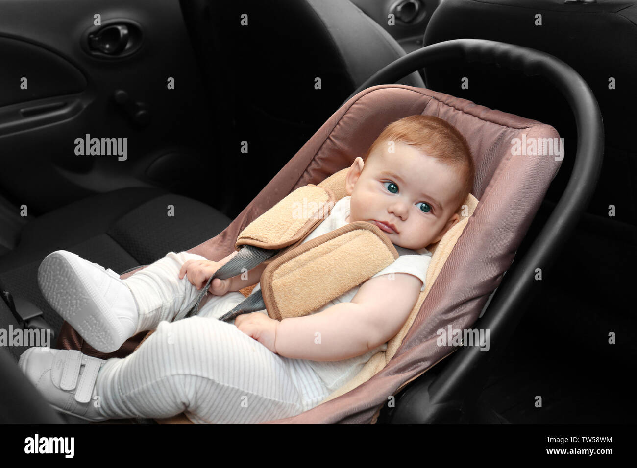 Adorable baby resting in child safety seat inside of car Stock Photo ...
