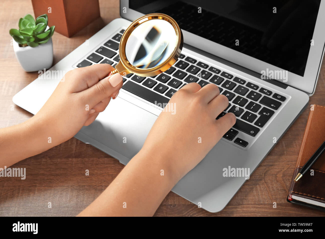 Woman holding magnifying glass over laptop. Internet search concept ...