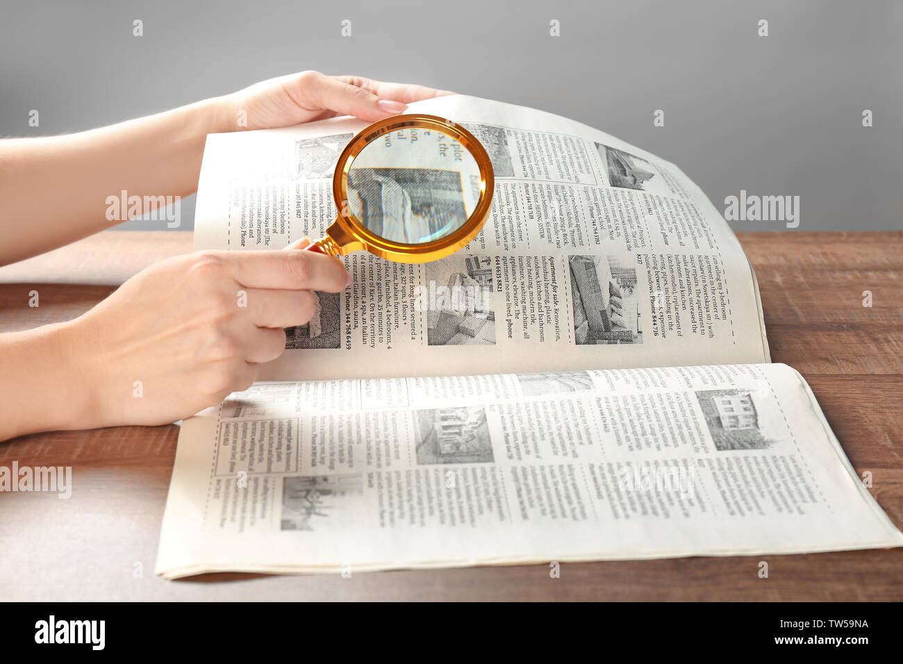 Woman holding magnifying glass over newspaper. Search concept Stock ...