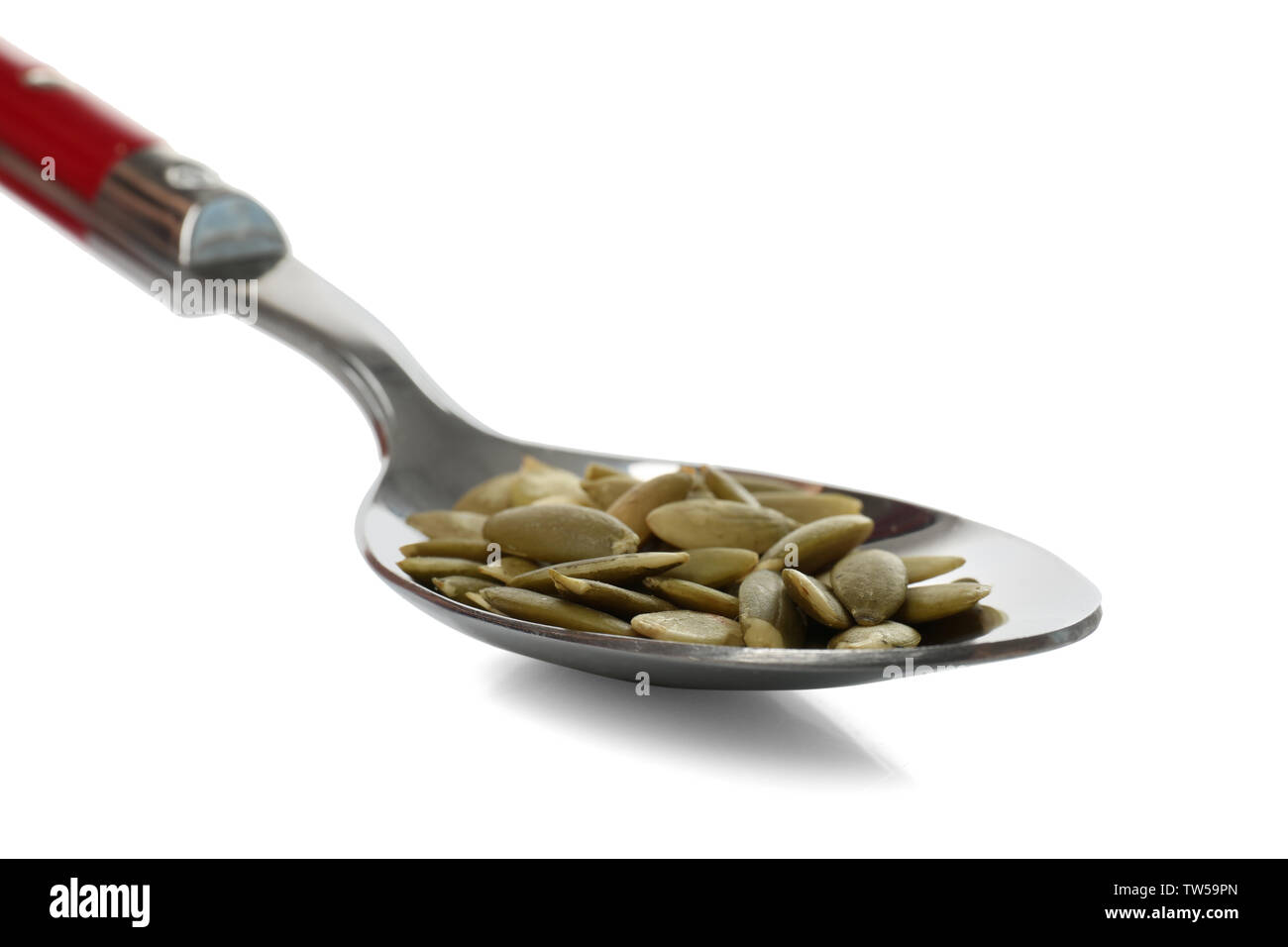 Pumpkin seeds in spoon on white background Stock Photo - Alamy