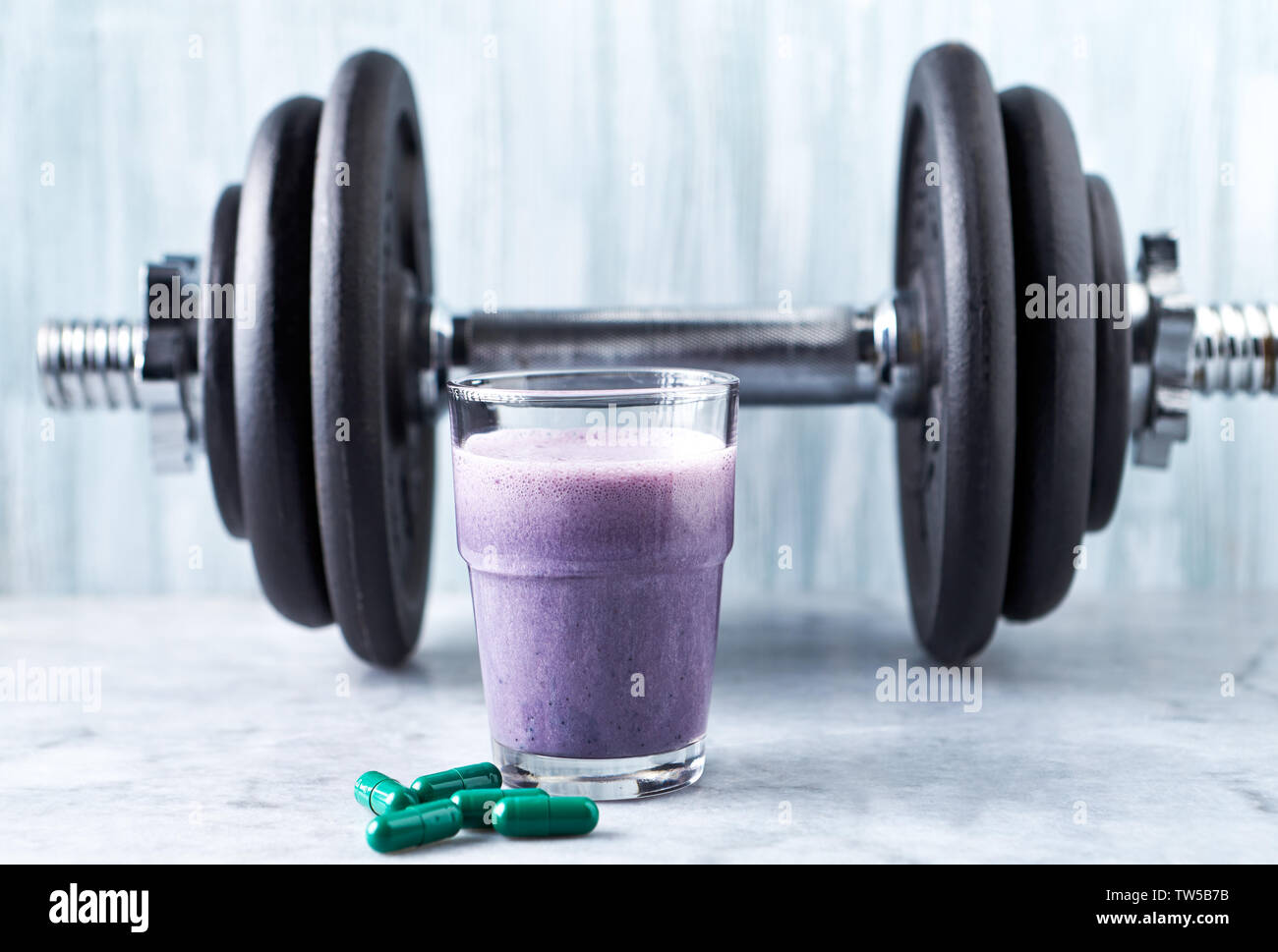 Glass of Protein Shake with milk and blueberries, L-Carnitine capsules ...