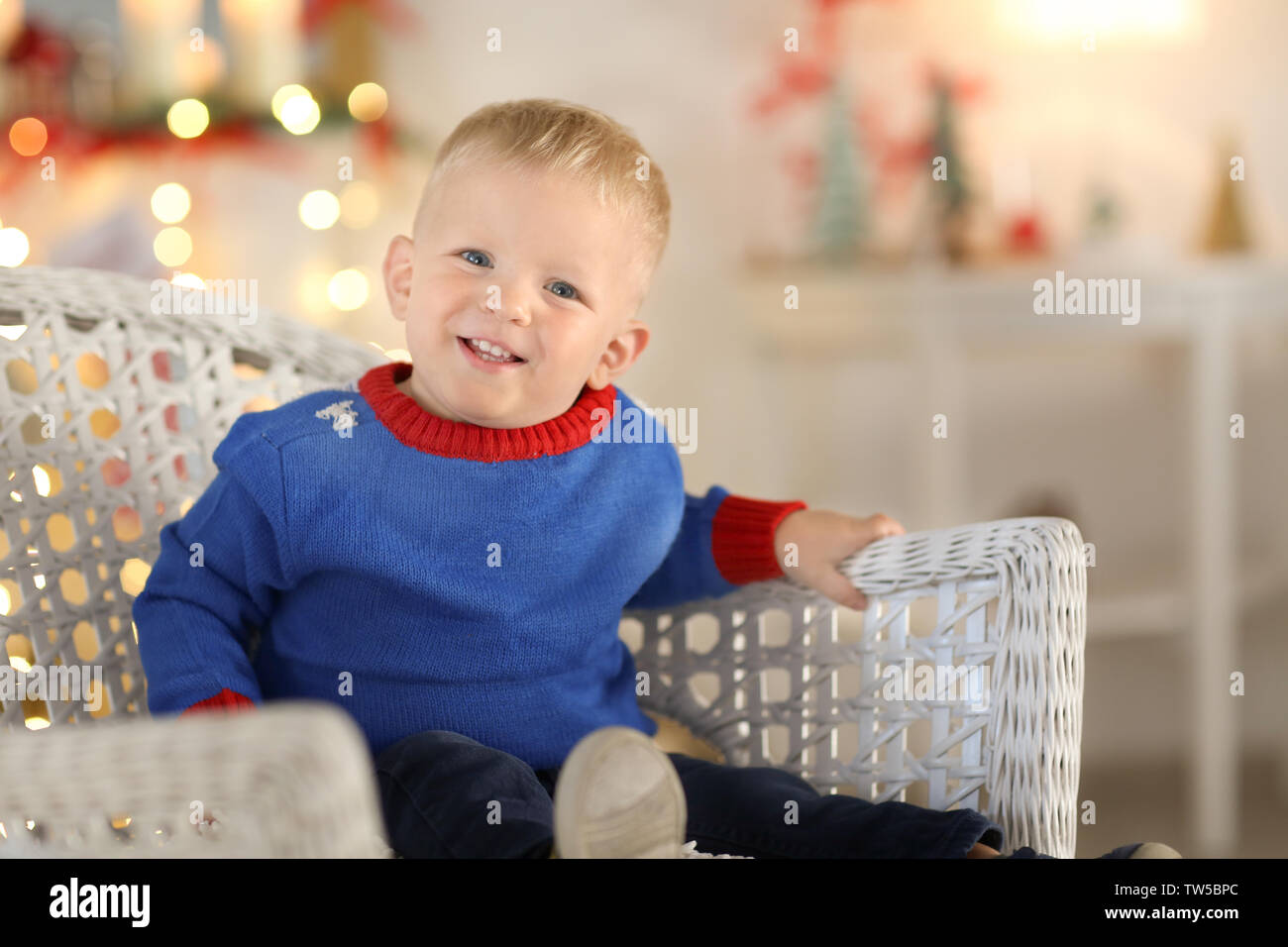 Cute little boy sitting in wicker chair on blurred background Stock ...