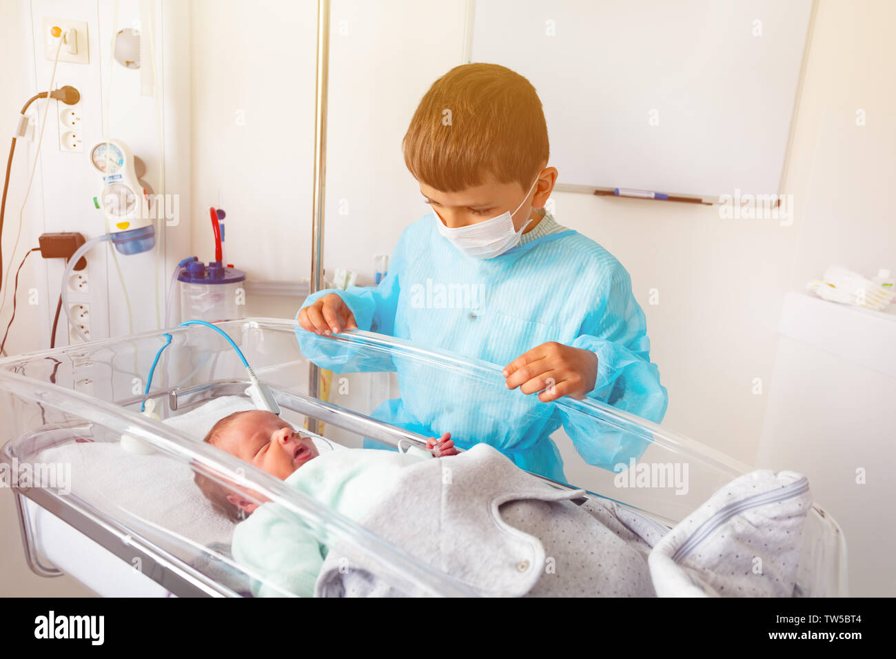 Baby brother and premature born infant child crib Stock Photo - Alamy