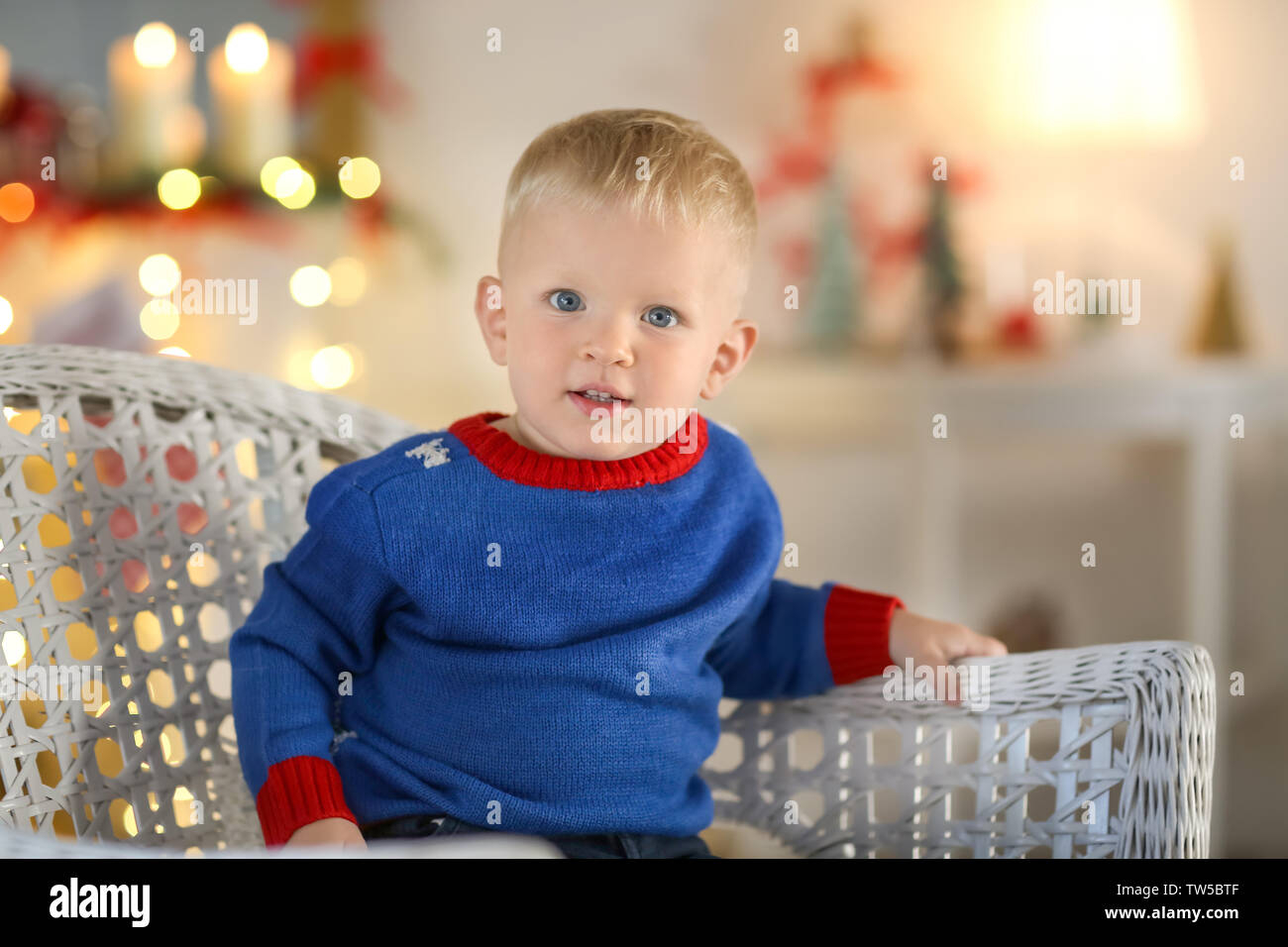 Cute little boy sitting in wicker chair on blurred background Stock ...