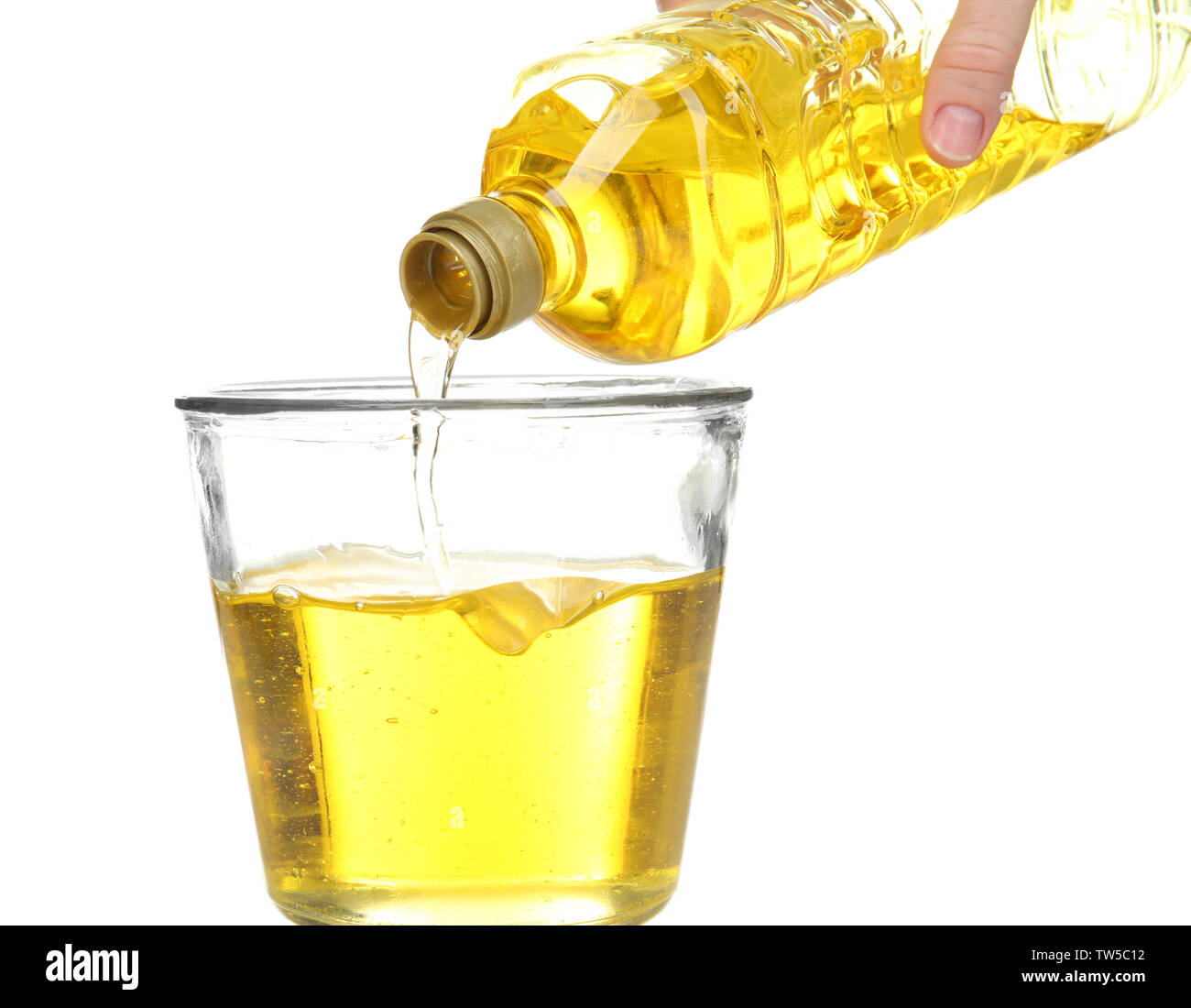 Pouring cooking oil into glass on white background Stock Photo - Alamy