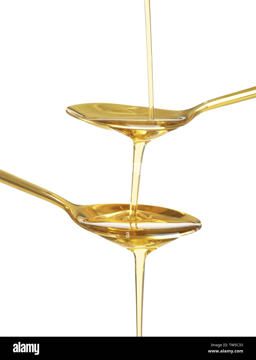 Two spoons and pouring cooking oil on white background Stock Photo - Alamy