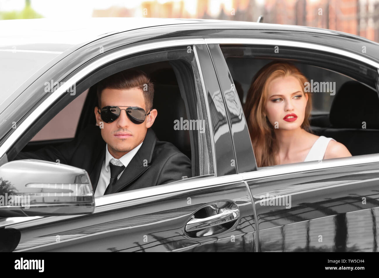 Young celebrity with bodyguard in modern car Stock Photo - Alamy