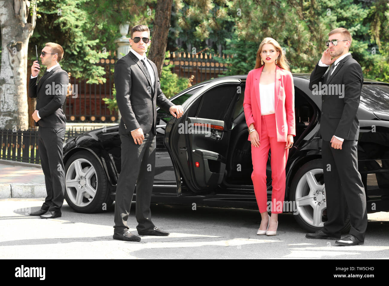 Famous celebrity with bodyguards near car outdoors Stock Photo - Alamy