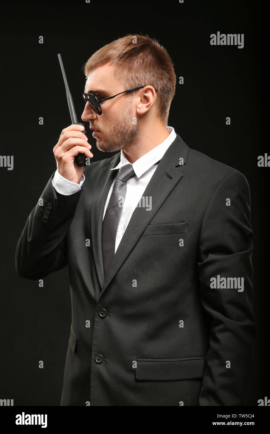 Handsome security guard on dark background Stock Photo - Alamy
