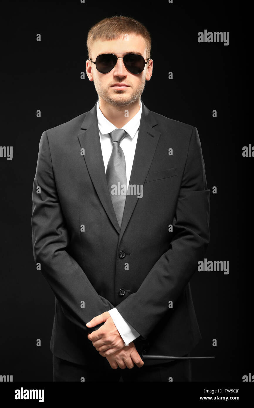 Handsome security guard on dark background Stock Photo - Alamy