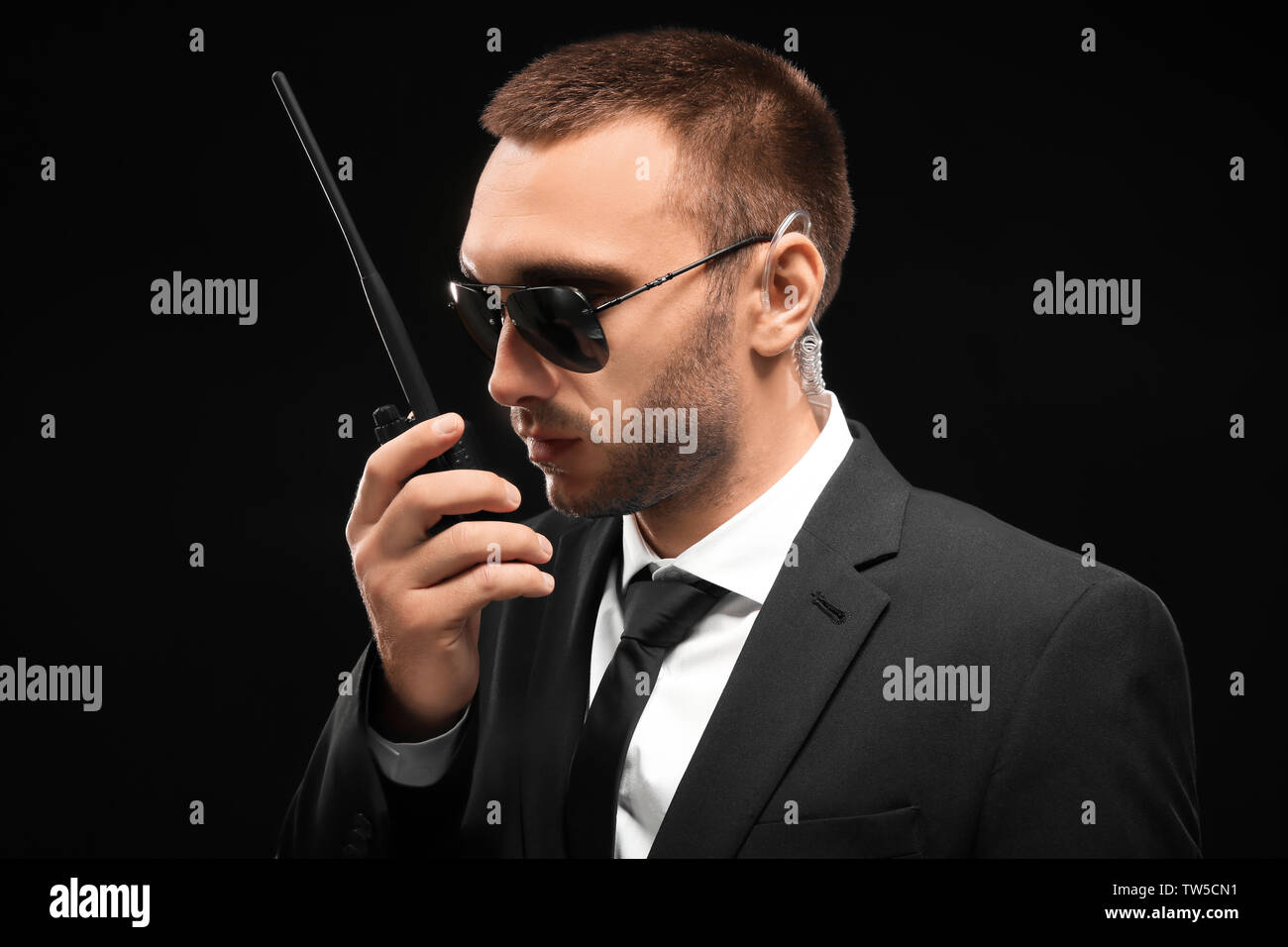 Handsome security guard on dark background Stock Photo - Alamy