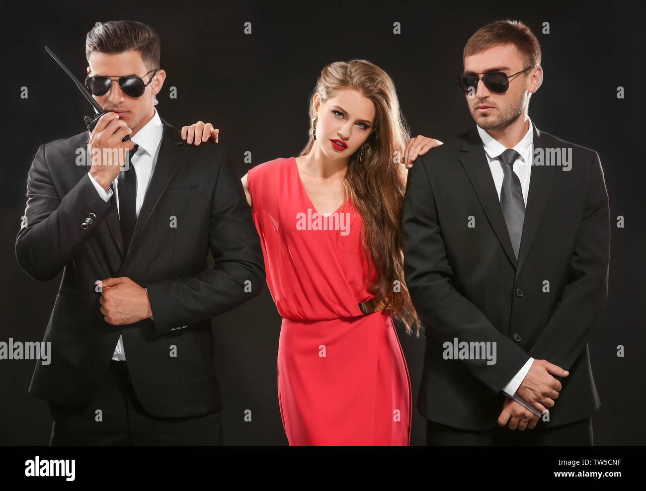 Famous celebrity with bodyguards on dark background Stock Photo - Alamy