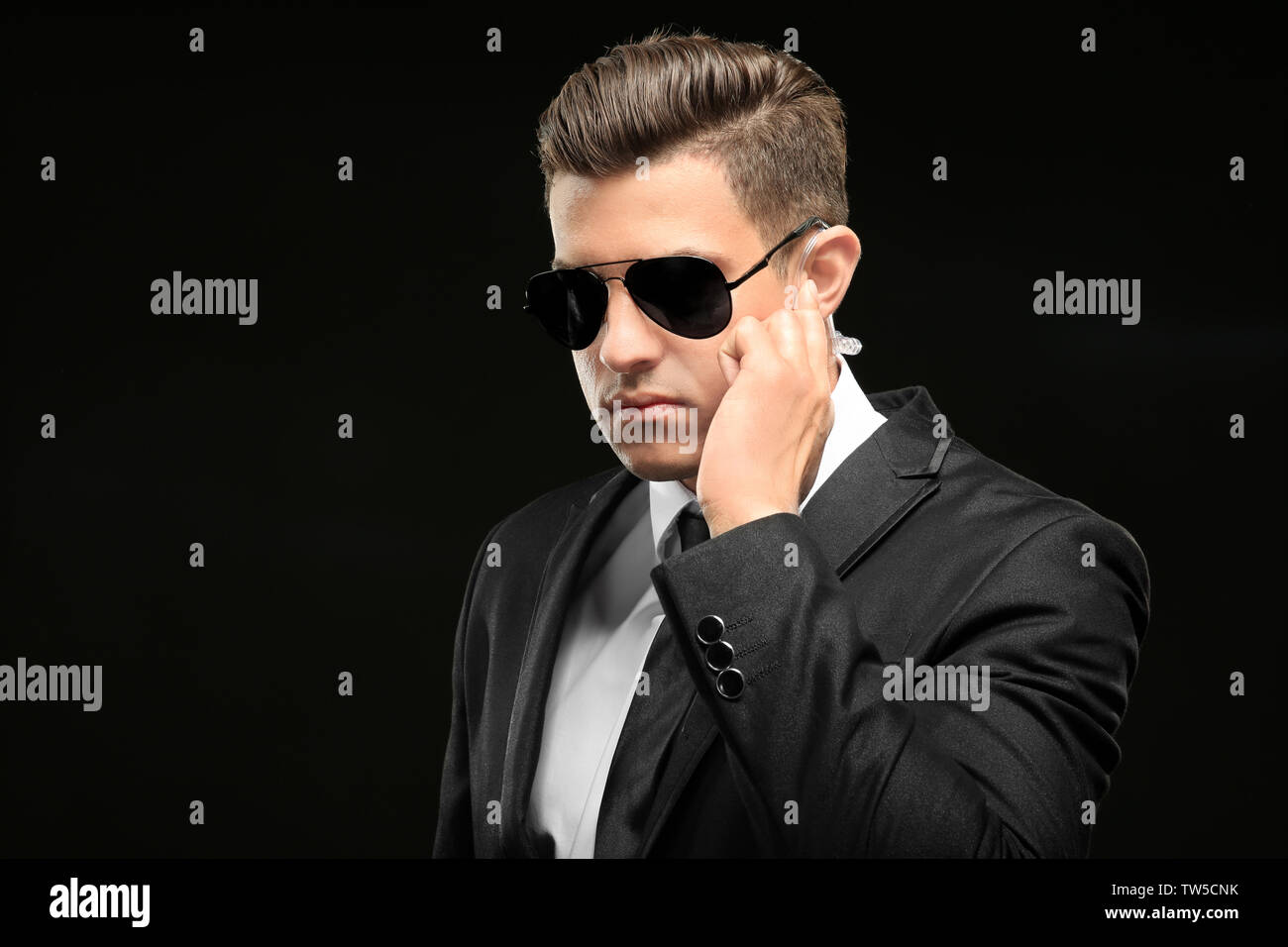 Handsome security guard on dark background Stock Photo - Alamy