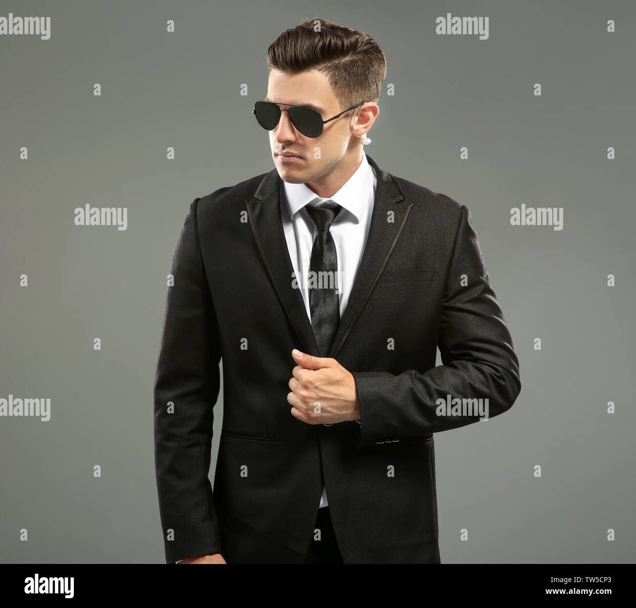 Handsome security guard on grey background Stock Photo - Alamy