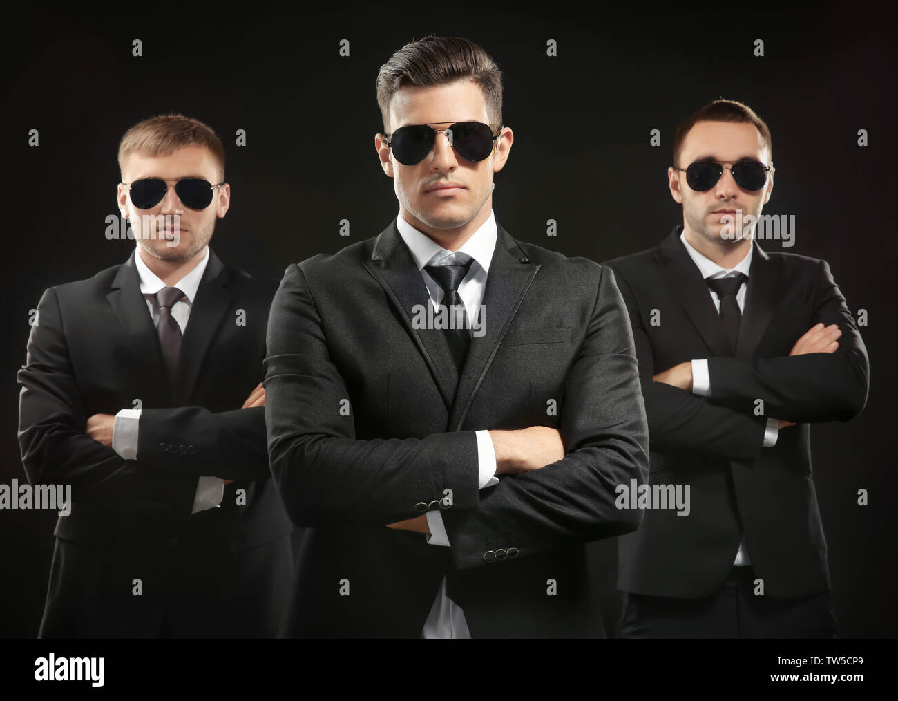 Handsome bodyguards on dark background Stock Photo - Alamy