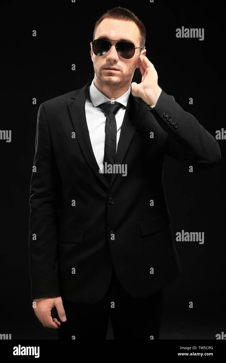 Handsome security guard on dark background Stock Photo - Alamy