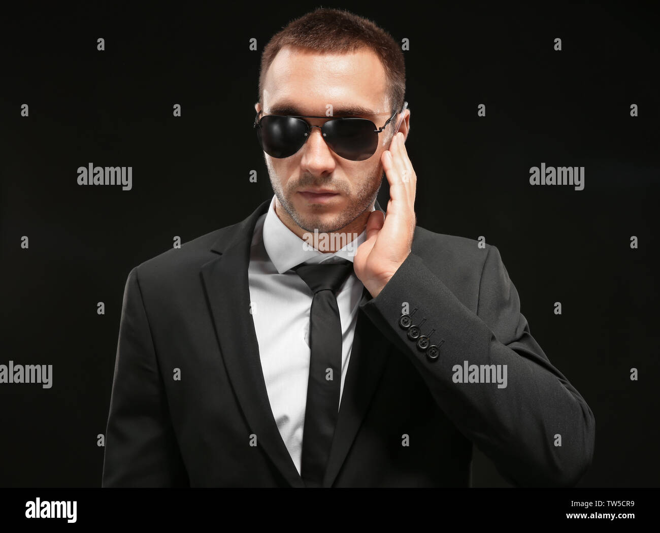 Handsome security guard on dark background Stock Photo - Alamy
