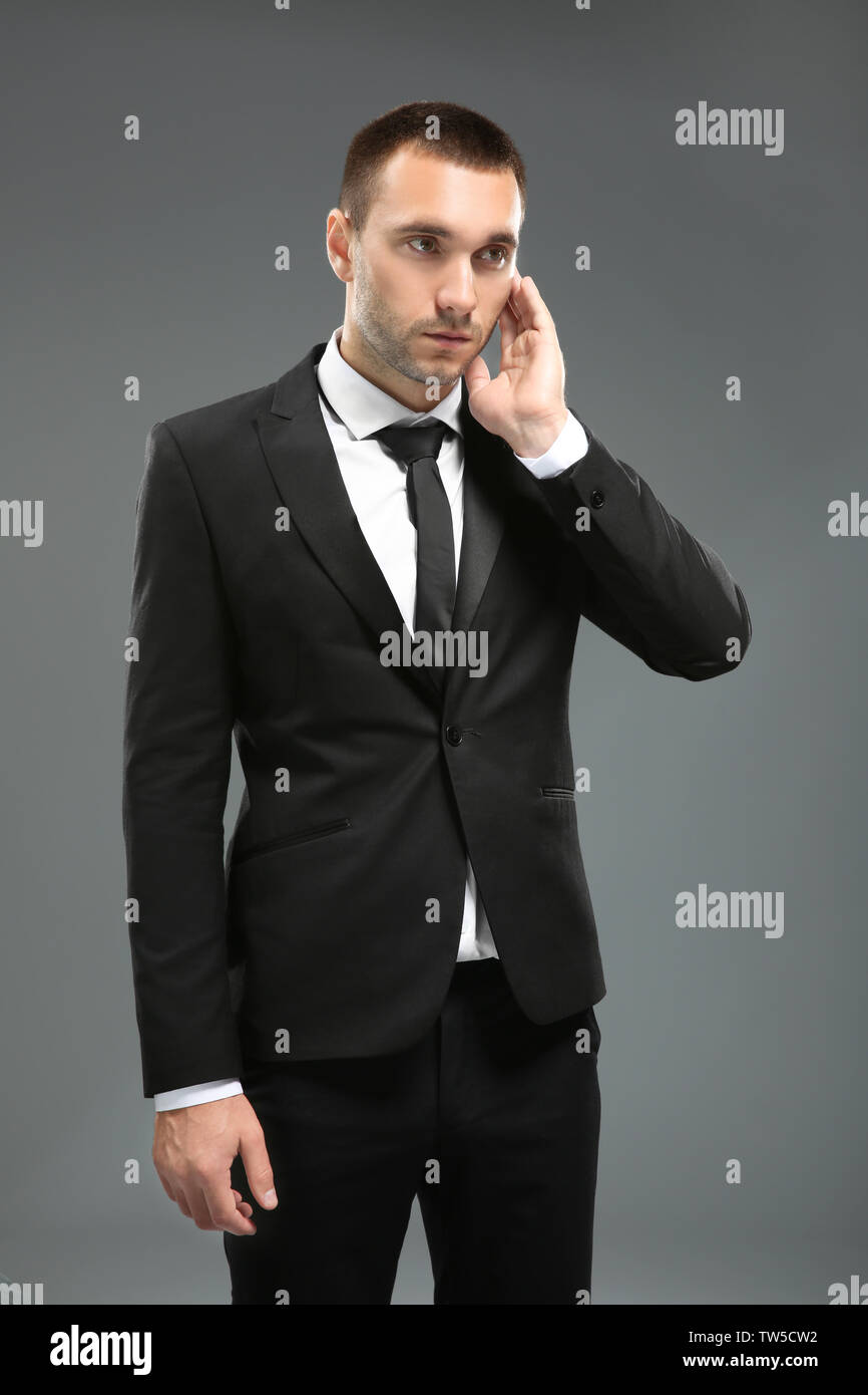 Handsome security guard on grey background Stock Photo - Alamy