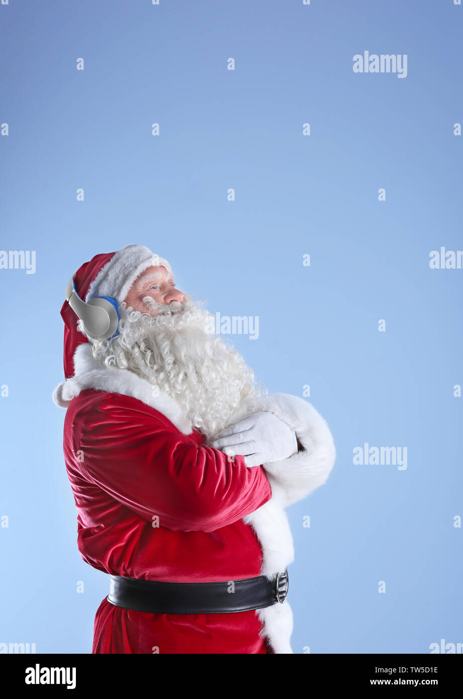 Santa Claus listening to music on color background Stock Photo - Alamy