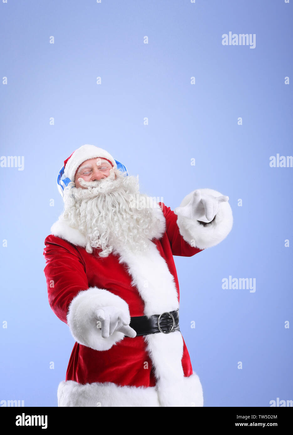 Santa Claus listening to music on color background Stock Photo - Alamy
