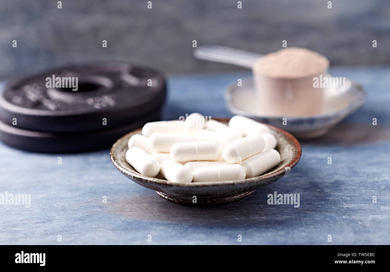 Creatine capsules, Scoop of Whey Protein and plates. Nutrition for ...