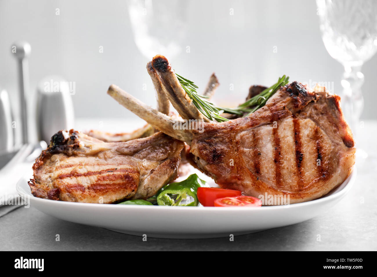 Juicy ribs served with vegetables on dinner table Stock Photo - Alamy