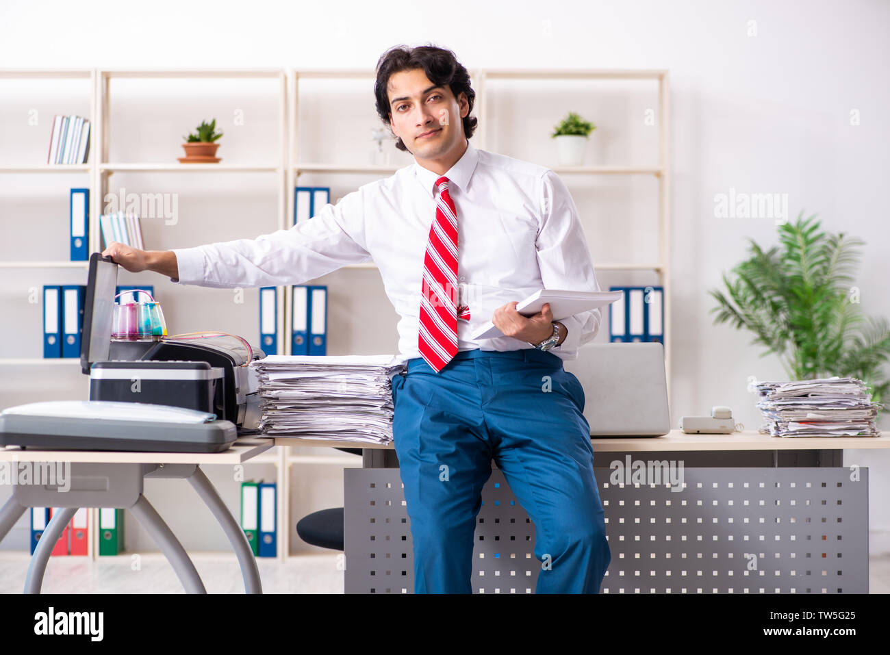 Young employee making copies at copying machine Stock Photo - Alamy