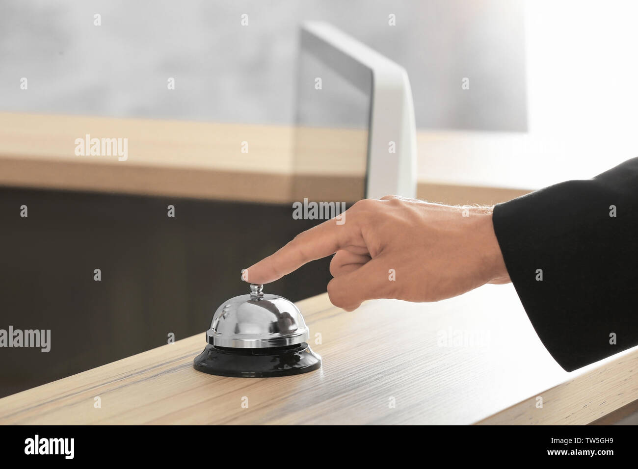 Man ringing service bell at hotel reception Stock Photo - Alamy