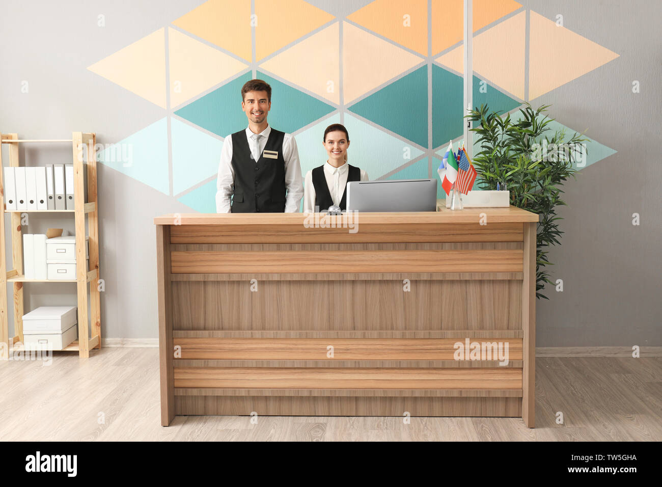 Female and male receptionists working in hotel Stock Photo - Alamy