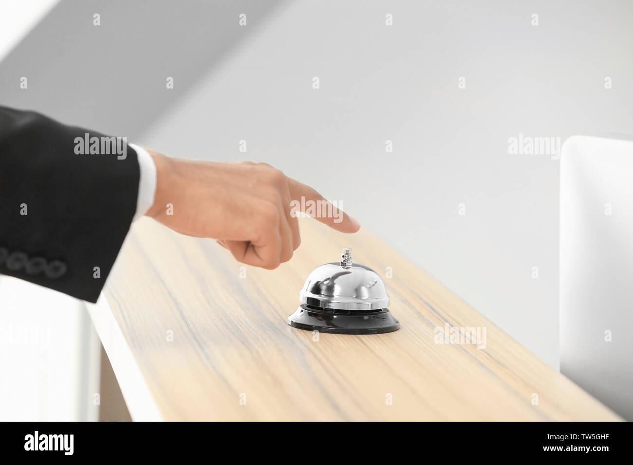 Man ringing service bell at hotel reception Stock Photo - Alamy