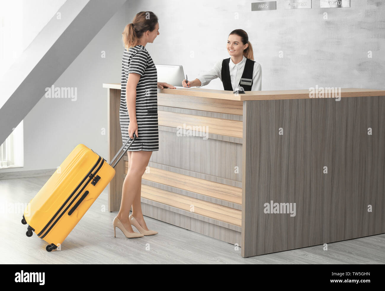 Young woman at reception desk in hotel Stock Photo - Alamy