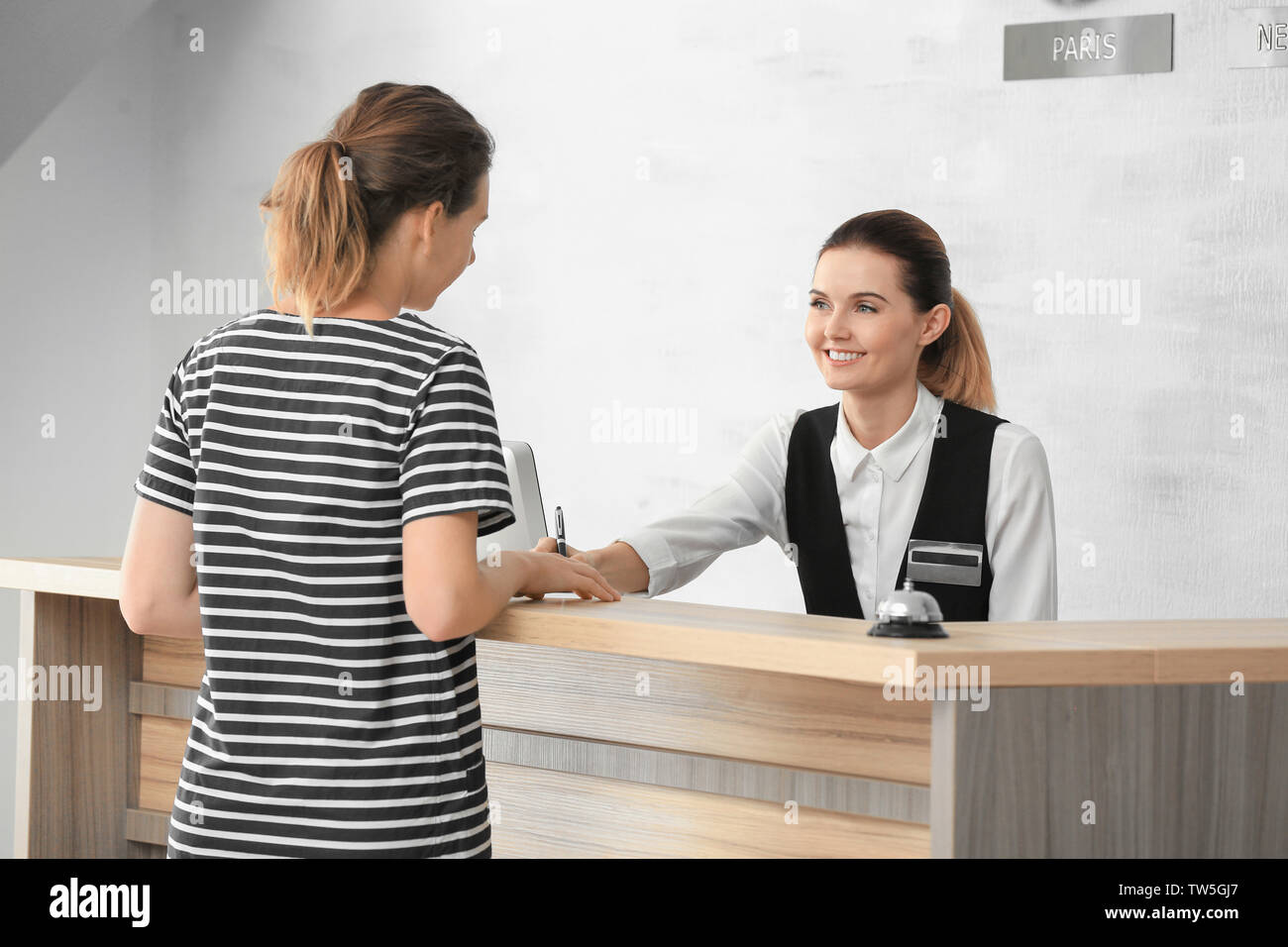 Young woman at reception desk in hotel Stock Photo - Alamy